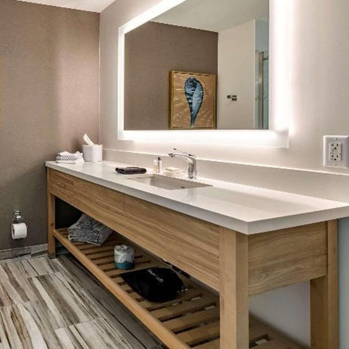 Bathroom wood vanity base and quartz top in Cambria Hotel
