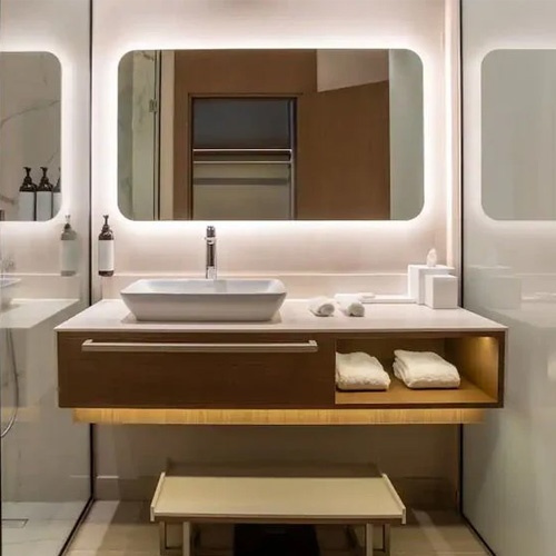 Hotel bath vanities with floating wood vanity and frameless vanity mirror